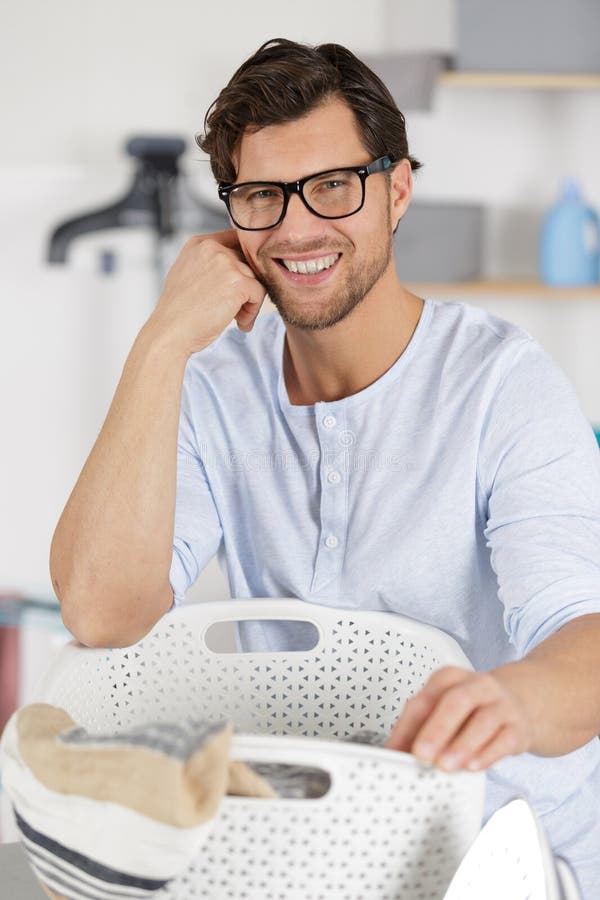 Happy Man Taking Clothes from Drying Rack Stock Photo - Image of ...