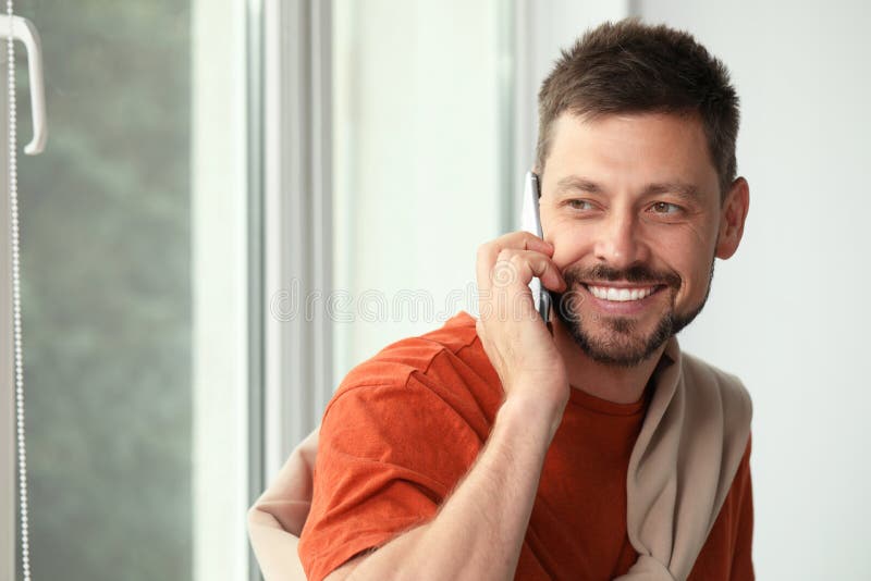 Happy Man Talking on Smartphone at Home, Space for Text Stock Image ...