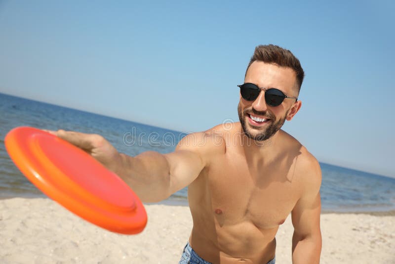 Happy Man Throwing Flying Disk at Beach on Sunny Day Stock Photo ...