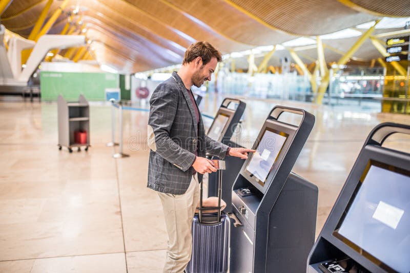 Happy Man Using the Check-in Machine at the Airport Getting the Stock ...