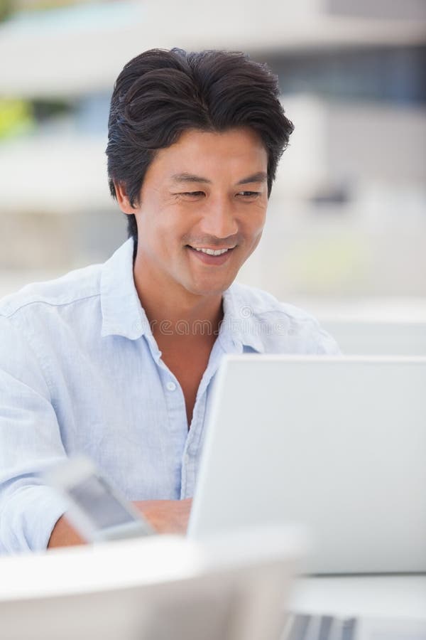 Happy man using his laptop stock photo. Image of household - 39429708
