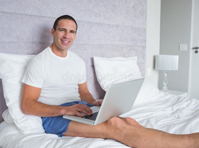 Happy Man Using Laptop on Bed Stock Photo - Image of calm, camera: 32516110