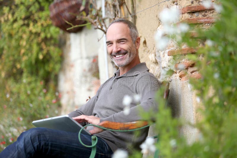 Happy Man Using Tablet from Bench in Garden Stock Image - Image of ...