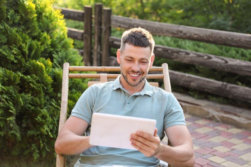 Man Using Tablet in Deck Chair Outdoors Stock Image - Image of relax ...