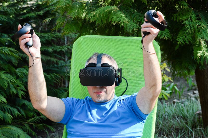 Happy Man Using a Virtual Reality Headset and Experiences a Computer ...