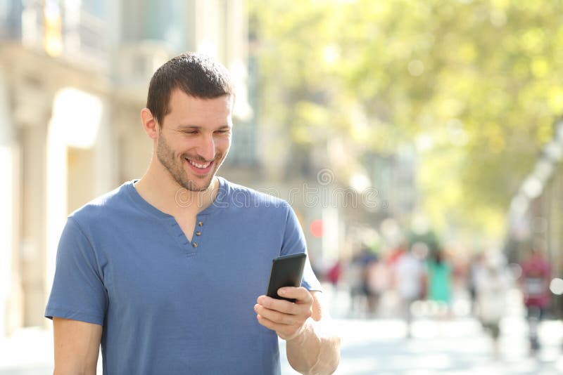 Happy Man Walking Using Mobile Phone in the Street Stock Image - Image ...