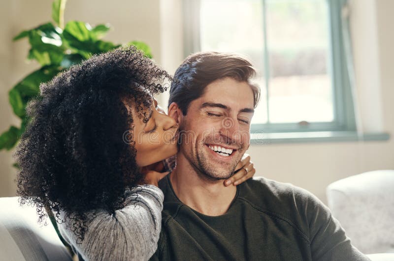 Happy Man Woman And Kiss On Cheek On Sofa For Love Affection And