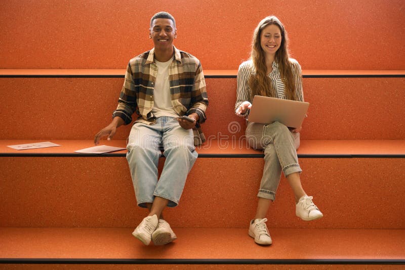 Happy Man and Woman Sitting on Steps while Using Laptop and Phone Stock ...