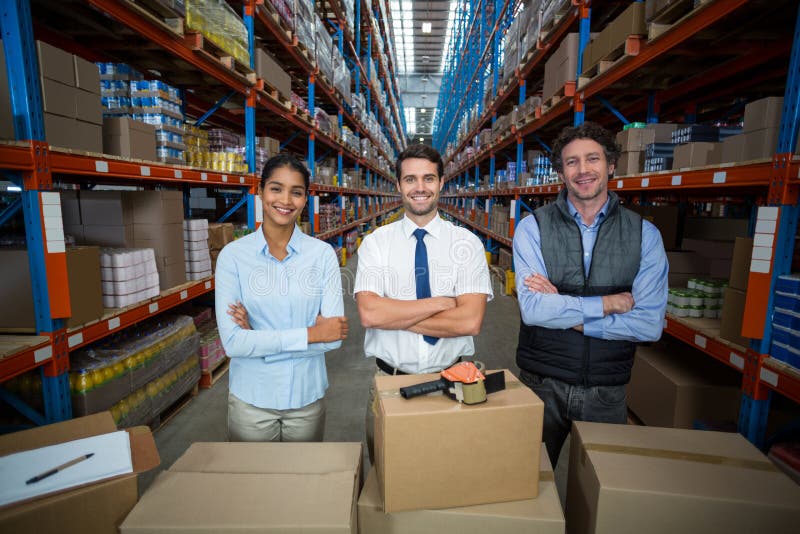 Happy Managers are Posing in Front of Cardboard Boxes with Crossed Arms ...