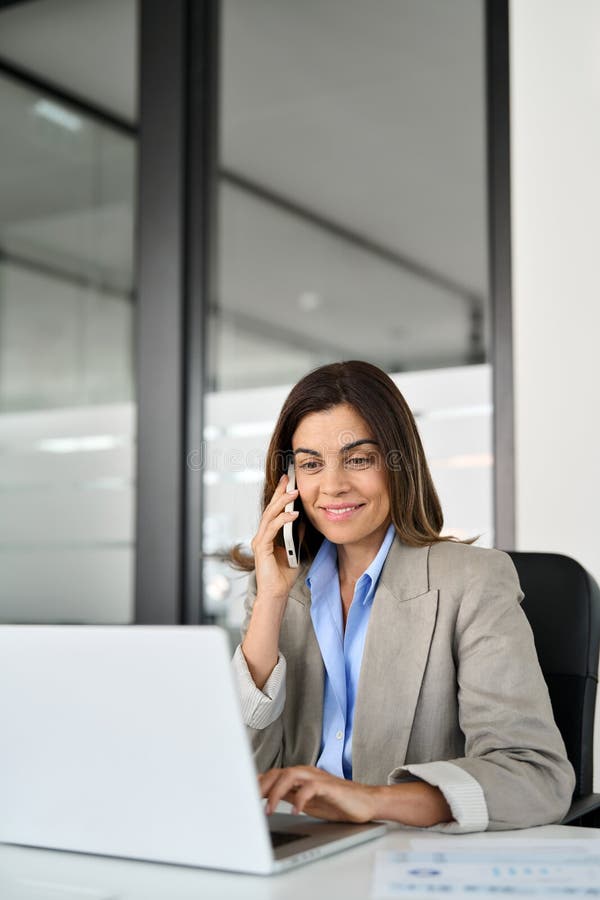 Happy Mature Business Man Wearing Suit Standing In Office Using Mobile