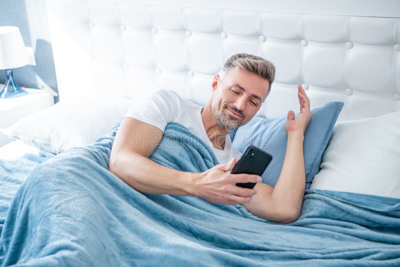 Happy Mature Man in Bed Chatting on Phone Stock Photo - Image of dial ...
