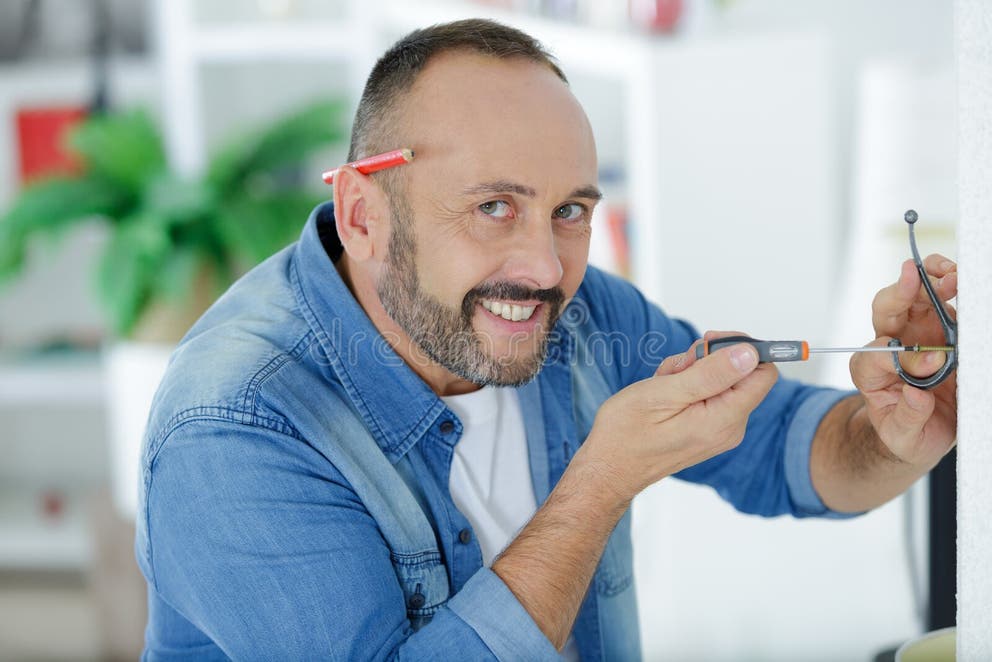 Happy mature man doing diy stock image. Image of house - 248310429