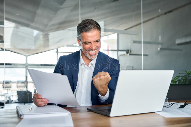 Happy Mature Business Man Wearing Suit Standing In Office Using Mobile