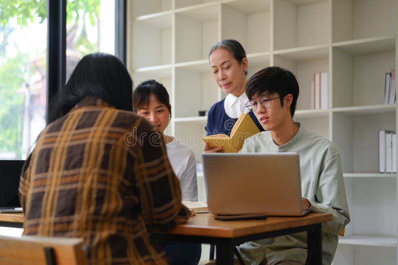 Happy Mature Professor Helping Group of Students at University Library Stock Photo - Image of ...