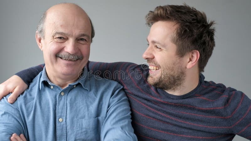 Happy Mature Senior Father And Grown Son Standing Together Hugging
