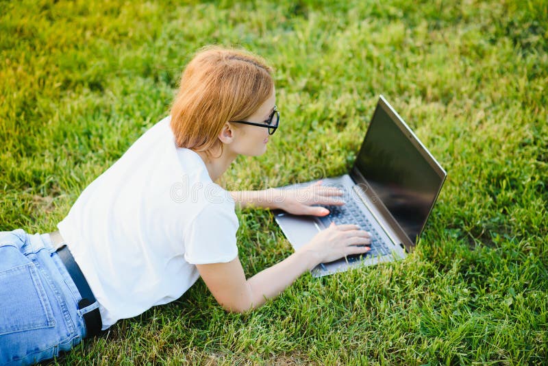 Happy Middle Aged Woman Lying on Green Grass Using Laptop Computer in ...