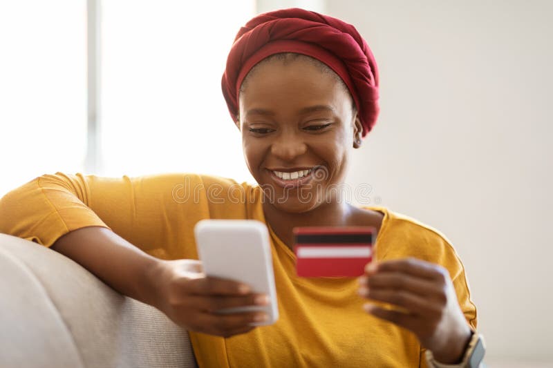 Happy Millennial Black Woman Using Smartphone And Bank Card Closeup