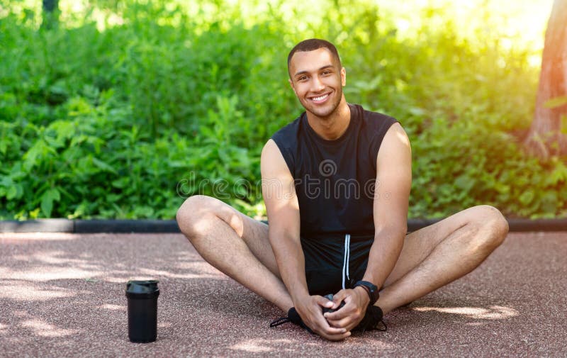 Happy Millennial Guy Doing Flexibility Exercises after Jogging at Park ...