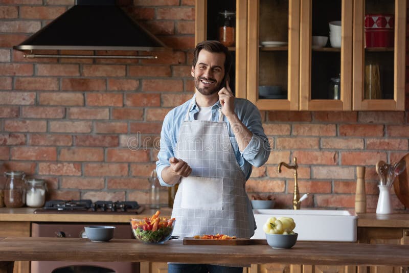 Happy Millennial Guy Talking on Cell while Cooking Dinner Stock Photo ...