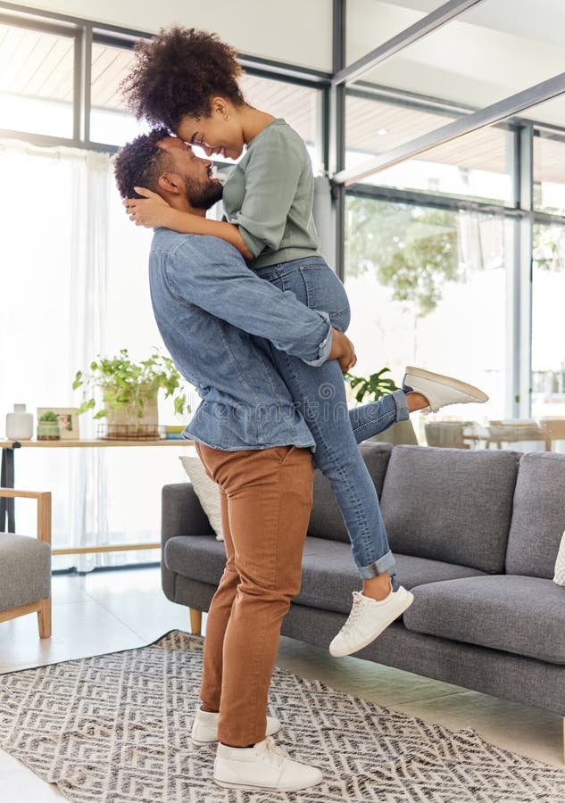 Happy Mixed Race Couple Hugging While Relaxing At Home Content