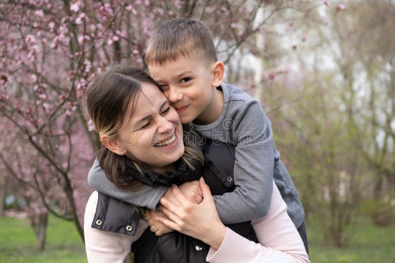 Happy Mom and Son Hugging among Cherry Blossoms in Spring. Stock Image ...