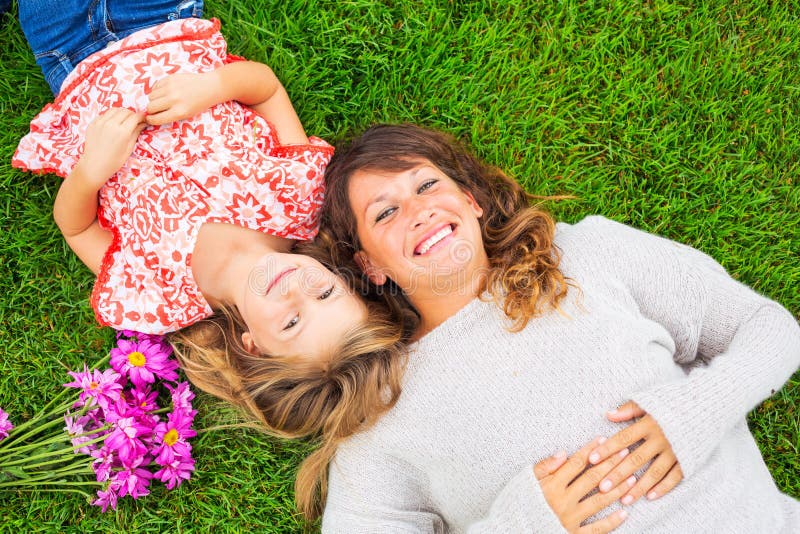 Mother And Daughter Lying Together Outside On Grass Stock Image Image