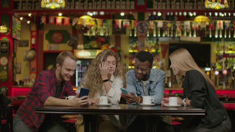 Happy Multi-ethnic Group of Friends Talking Using Smartphones at. Happy ...