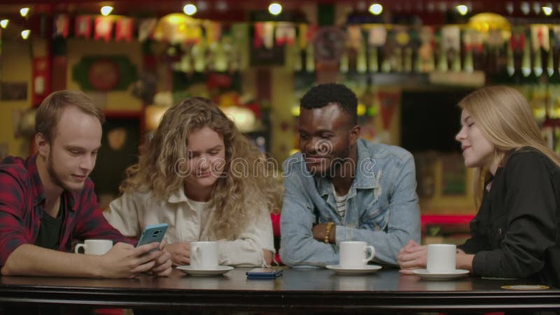 Happy Multi-ethnic Group of Friends Talking Using Smartphones at. Happy ...