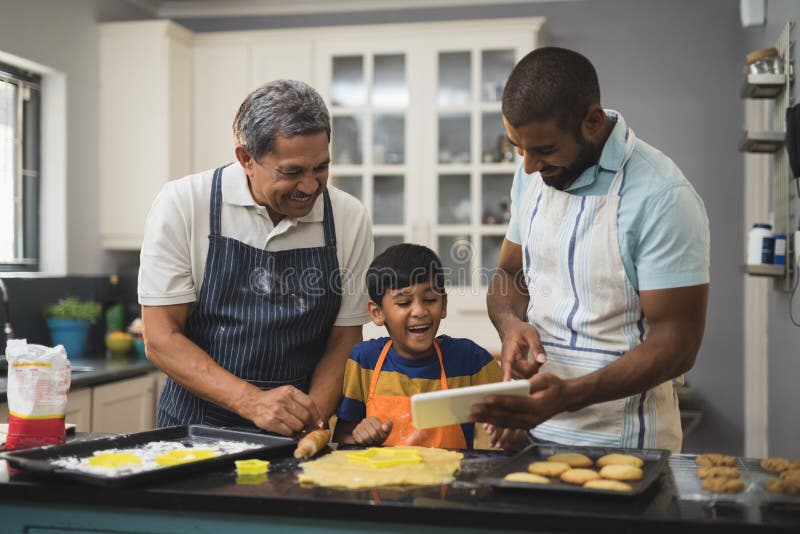 Happy Multi-generation Family Using Digital Tablet while Preparing Food ...