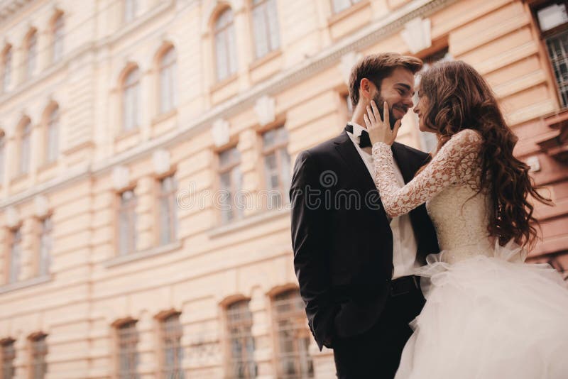 Happy Newlywed Couple Hugging And Kissing In Old European Town Street