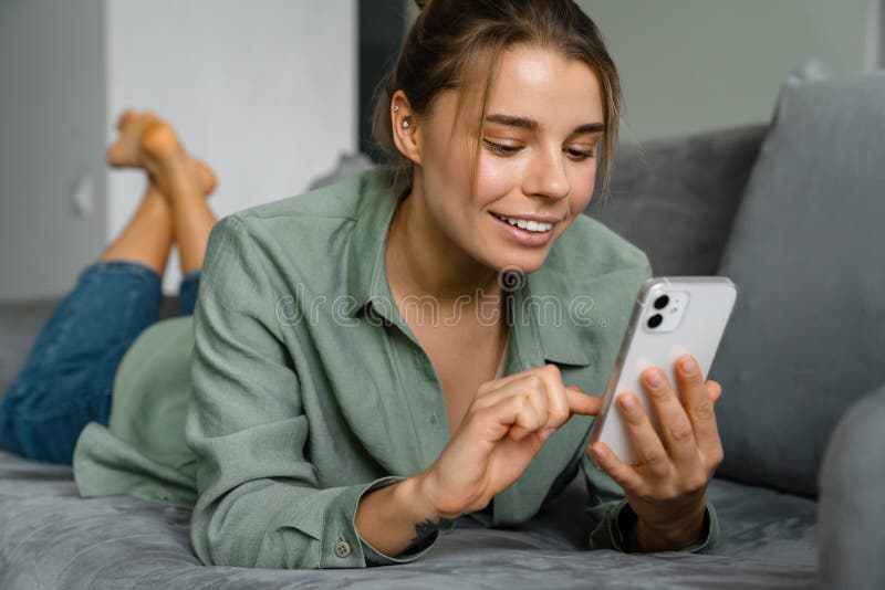 Happy Nice Woman Using Mobile Phone while Lying on Sofa Stock Image ...