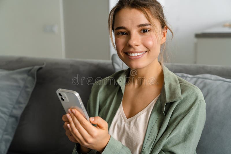Happy Nice Woman Using Mobile Phone while Sitting on Sofa Stock Photo ...
