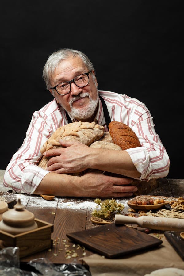 Happy Old Baker Looking at Camera and Smiling while Hugging Loaves of ...