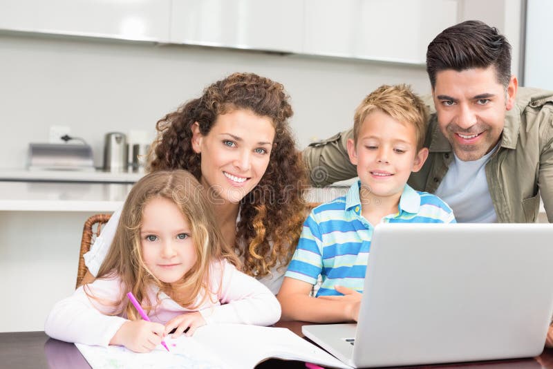 Happy Parents Colouring and Using Laptop with Their Children Stock ...