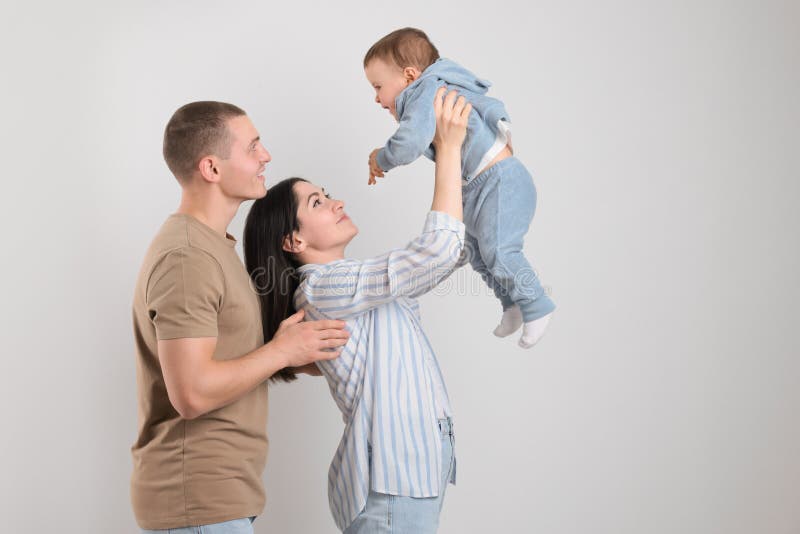 Happy Parents with Cute Child on Light Background Stock Image - Image ...
