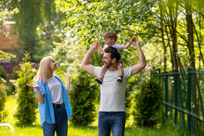 Happy Parents Spending Time Together with Their Kid Outdoors Stock ...