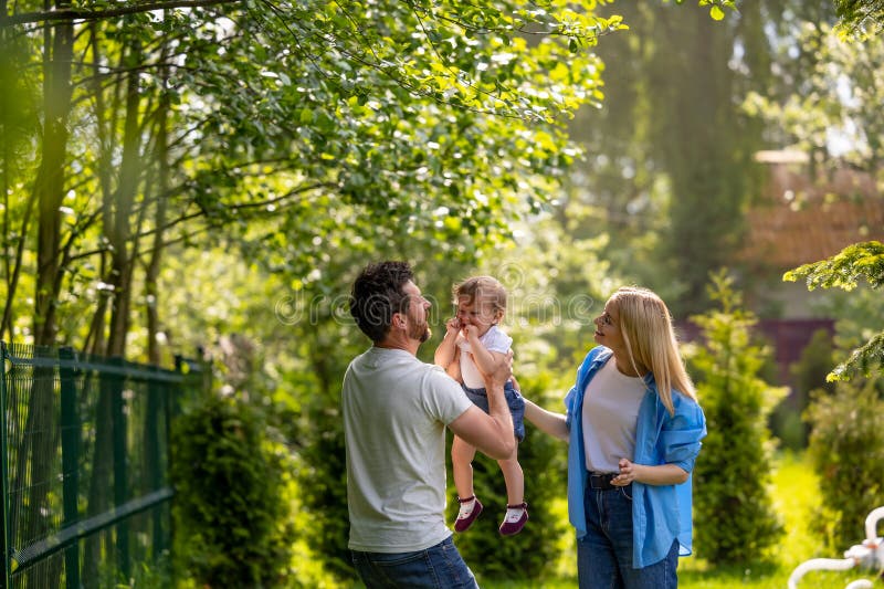 Happy Parents Spending Time Together with Their Kid Outdoors Stock ...