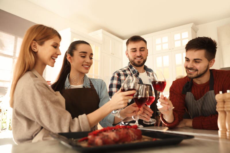 People Drinking Wine while Cooking Food in Kitchen Stock Photo - Image ...