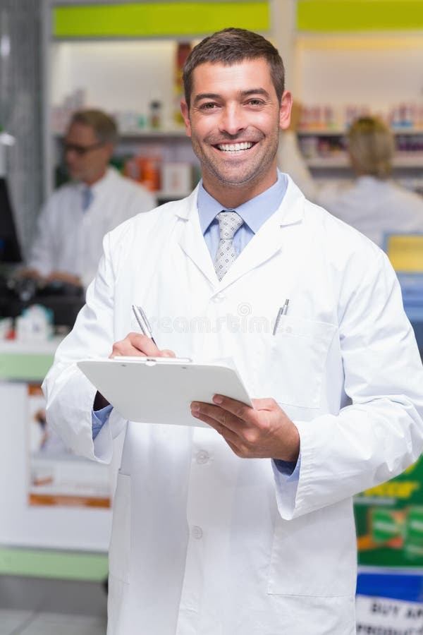 Happy Pharmacist Writing on Clipboard Stock Photo - Image of ...