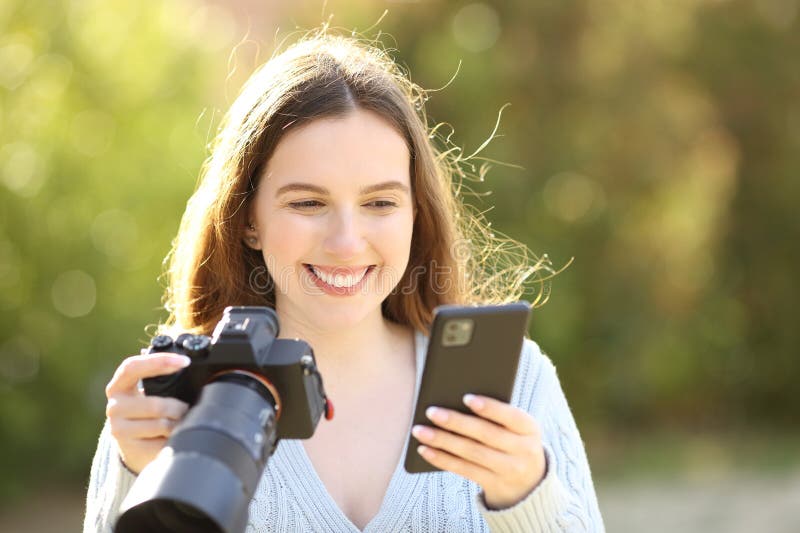 Happy Photographer Checking Phone Holding Camera Stock Photo - Image of ...
