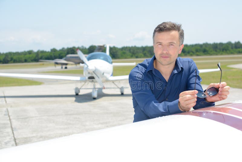 Happy Pilot and Two Pretty Stewardesses Standing Together, Leaning on ...