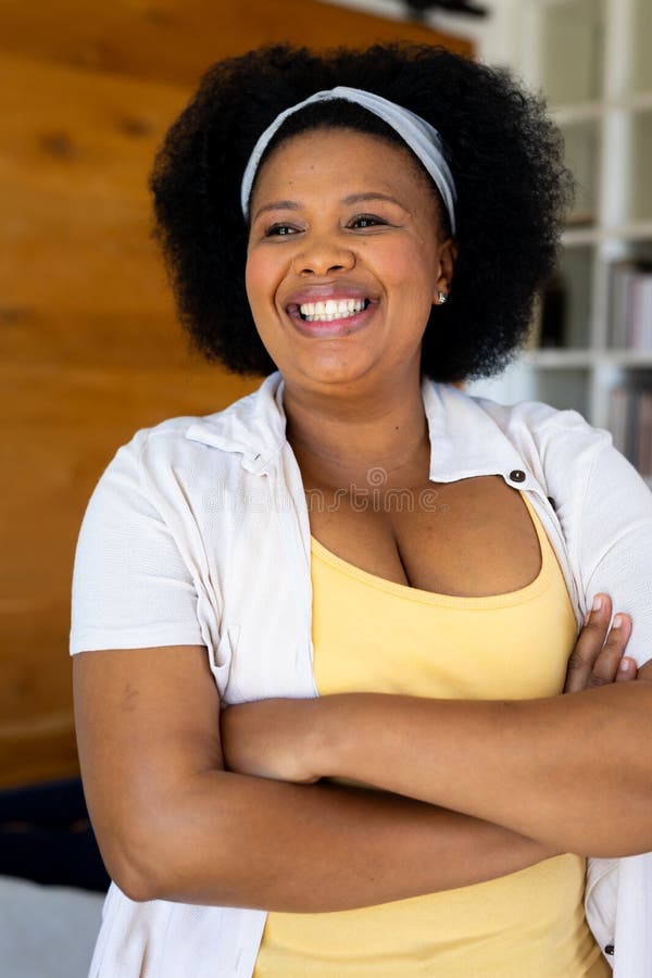 Happy Plus Size African American Woman Sitting On Sofa Talking On