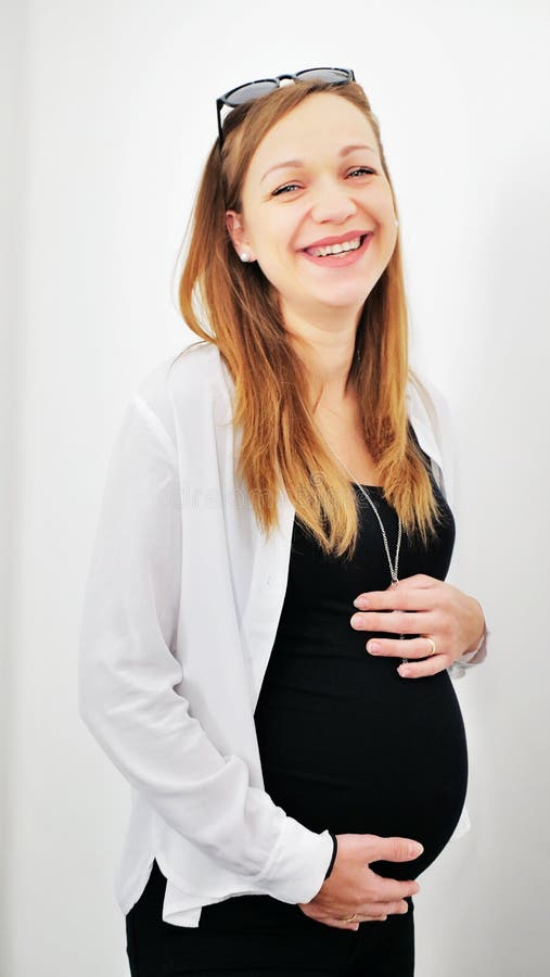 Happy Pregnancy Concept Expectant Mother To Be Touching Belly Smiling At Camera Standing Over