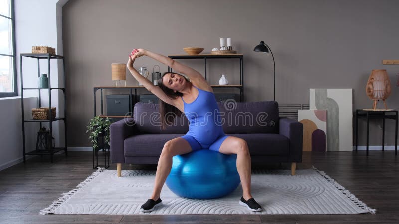 Pregnant Woman Doing Warm Up For Legs Using Fitball On White Background