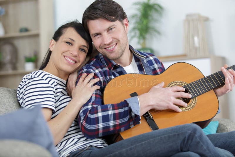 Happy Relaxed Couple with Guitar Sitting on Couch at Home Stock Image ...