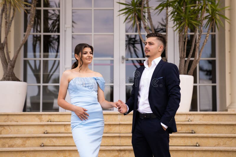 Happy Romantic Caucasian Couple Holding Hands in Front of the Stairs ...