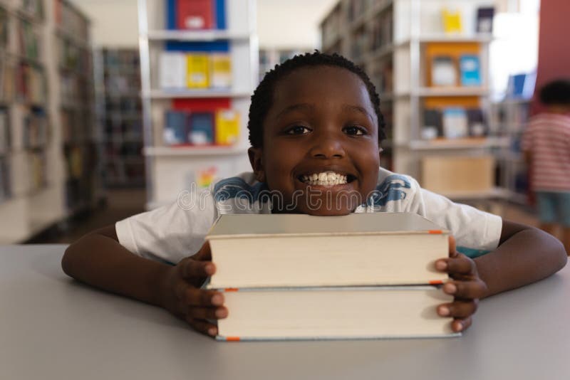 Happy Schoolboy Leaning His Face on Books and Looking at Camera on ...