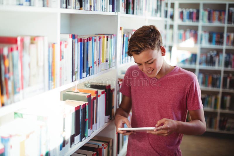 Happy Schoolboy Using Digital Tablet in Library Stock Photo - Image of ...