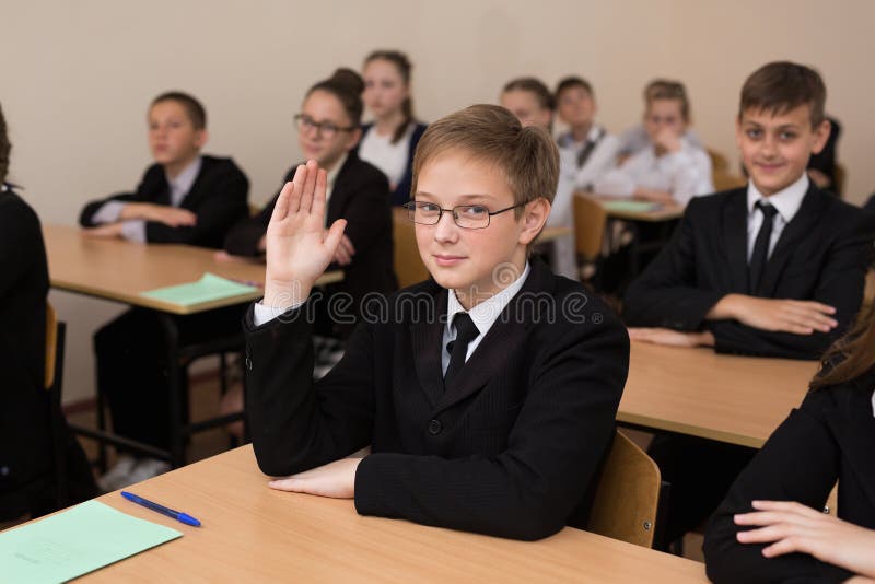 Happy Schoolchildren Sit at a Desk in the Classroom. Stock Photo ...