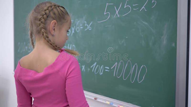 Happy Schoolgirl with Chalk Solves Examples on Mathematics on School ...